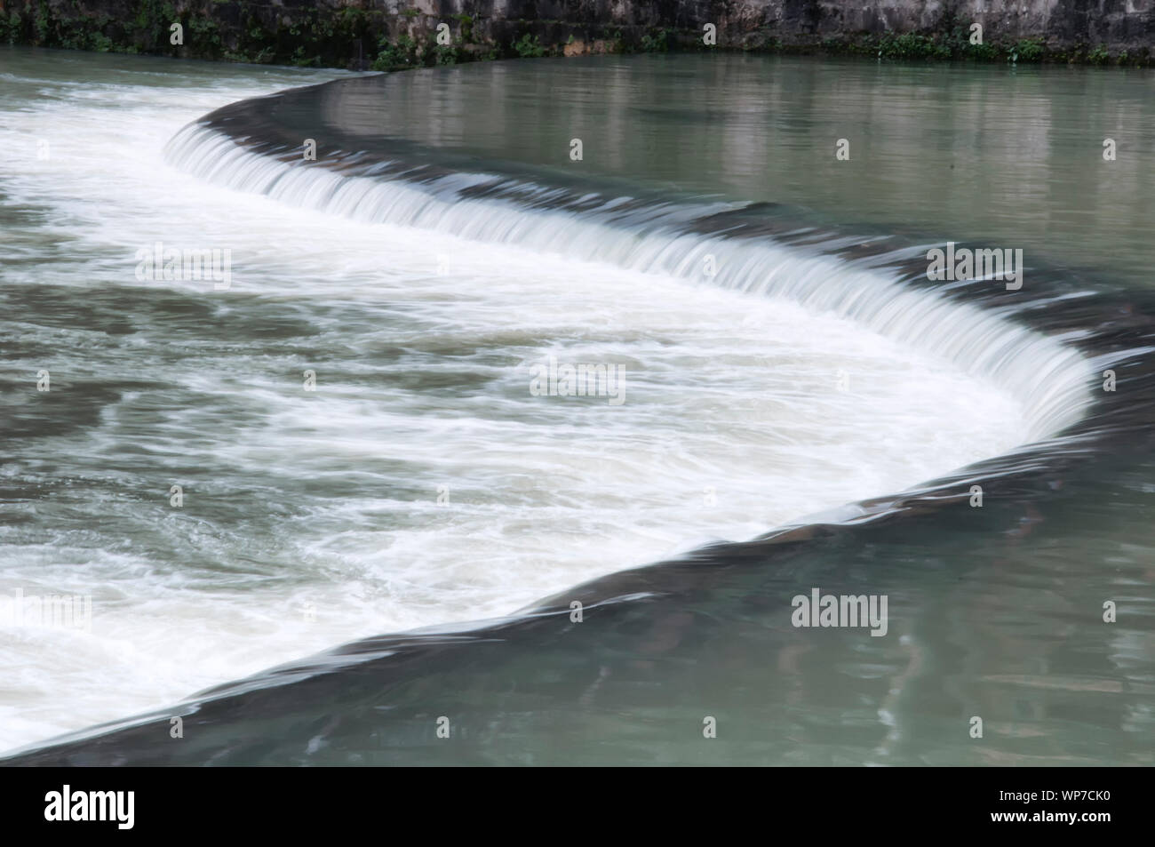 A curved manmade waterfall on the tuo jiang river in Fenghuang Ancient ...