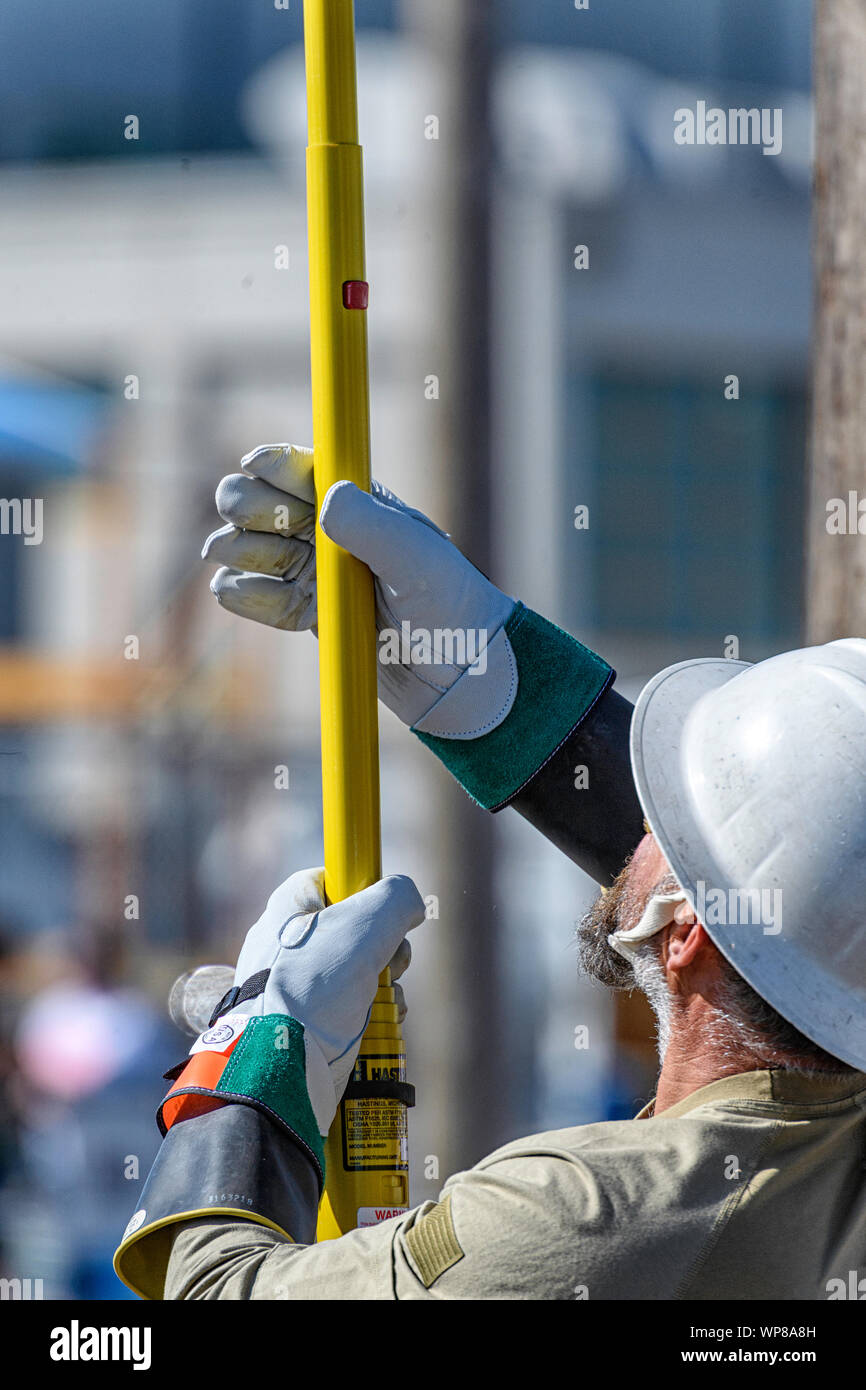 Construction worker at a job site holding a pole Stock Photo - Alamy