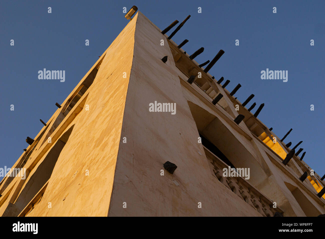 Sharp edge of building corner at sunset highlights on face of wall ...
