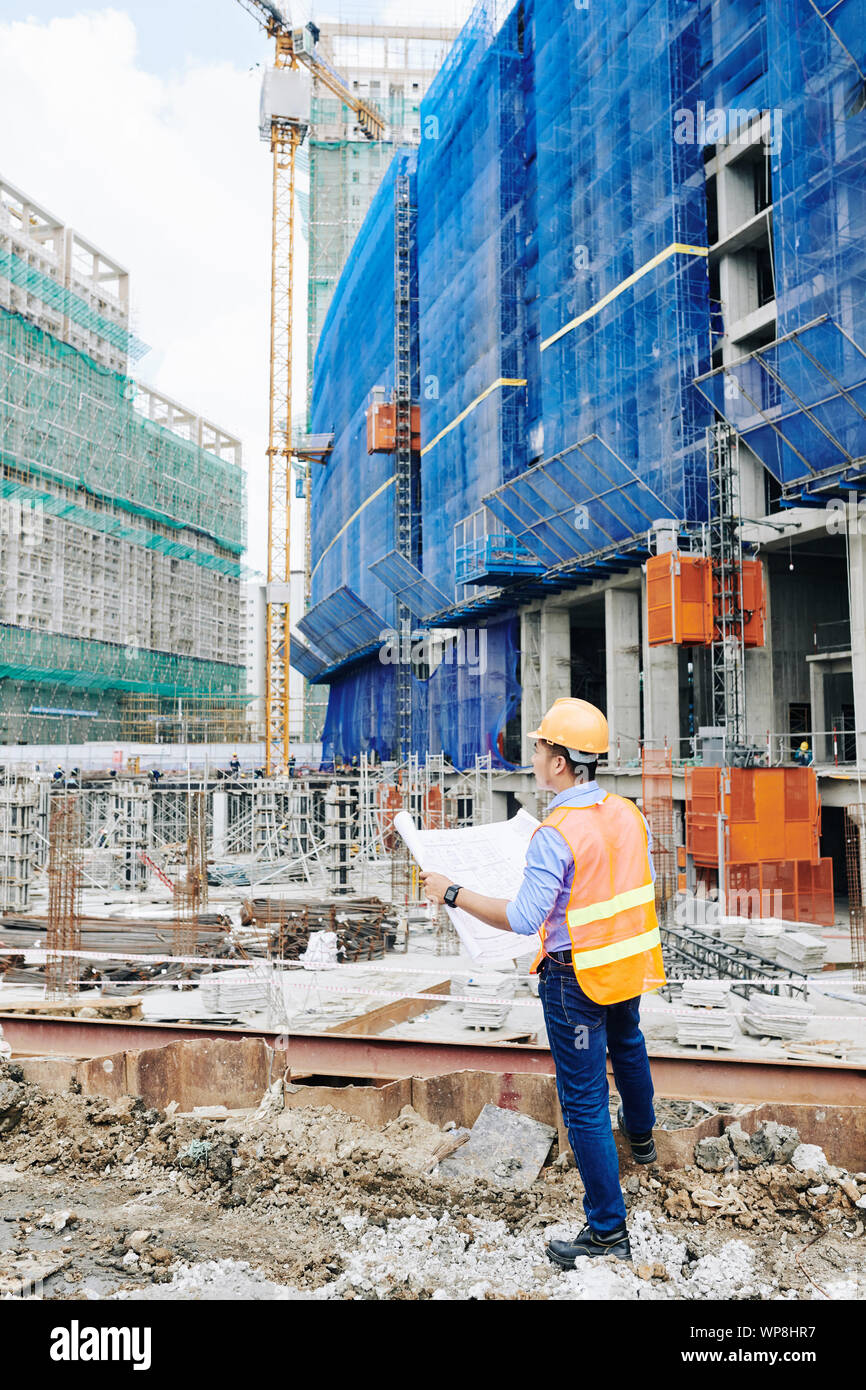 Civil engineer checking building blueprint when working on new project ...