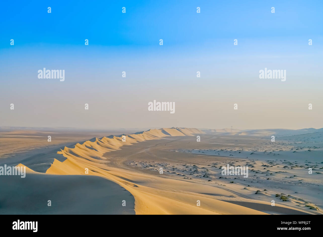 Desert at sunrise, Sealine Desert formations with low sun highlighting ...
