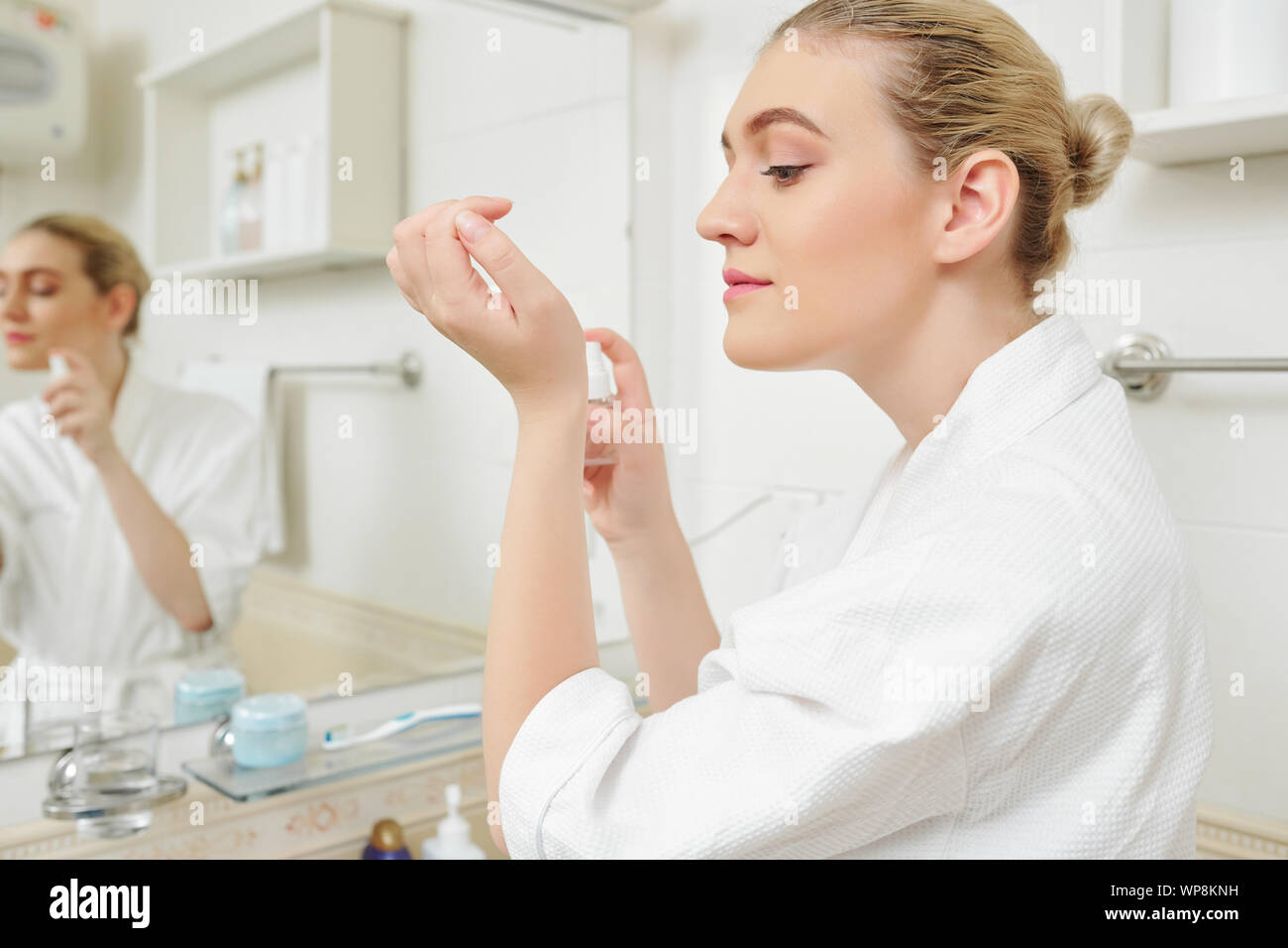 Spraying perfume on her wrist hi-res stock photography and images - Alamy