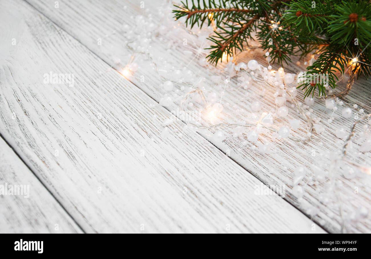 christmas tree branch and lights on wooden background Stock Photo - Alamy