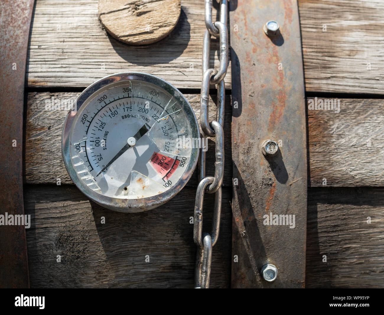 Broken thermometer gauge and chain sitting on top of smoker grill bbq ...