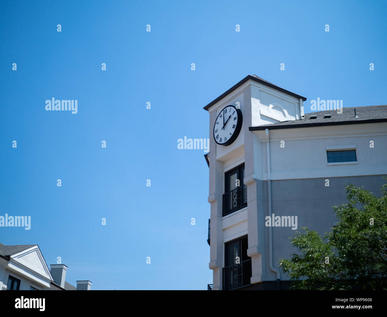 Corner of contemporary building with clock tower at 2 oclock in ...