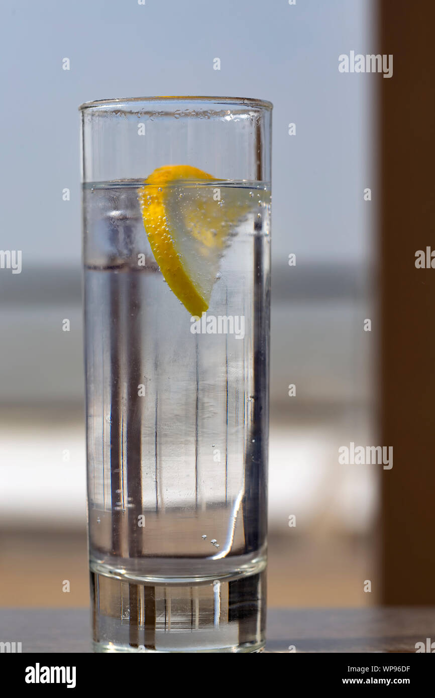 Glass of tonic water with a slice of lemon - beach background Stock ...