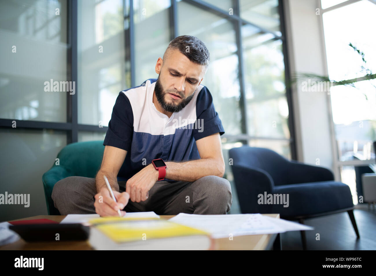 Bearded man feeling overloaded with accounting Stock Photo - Alamy