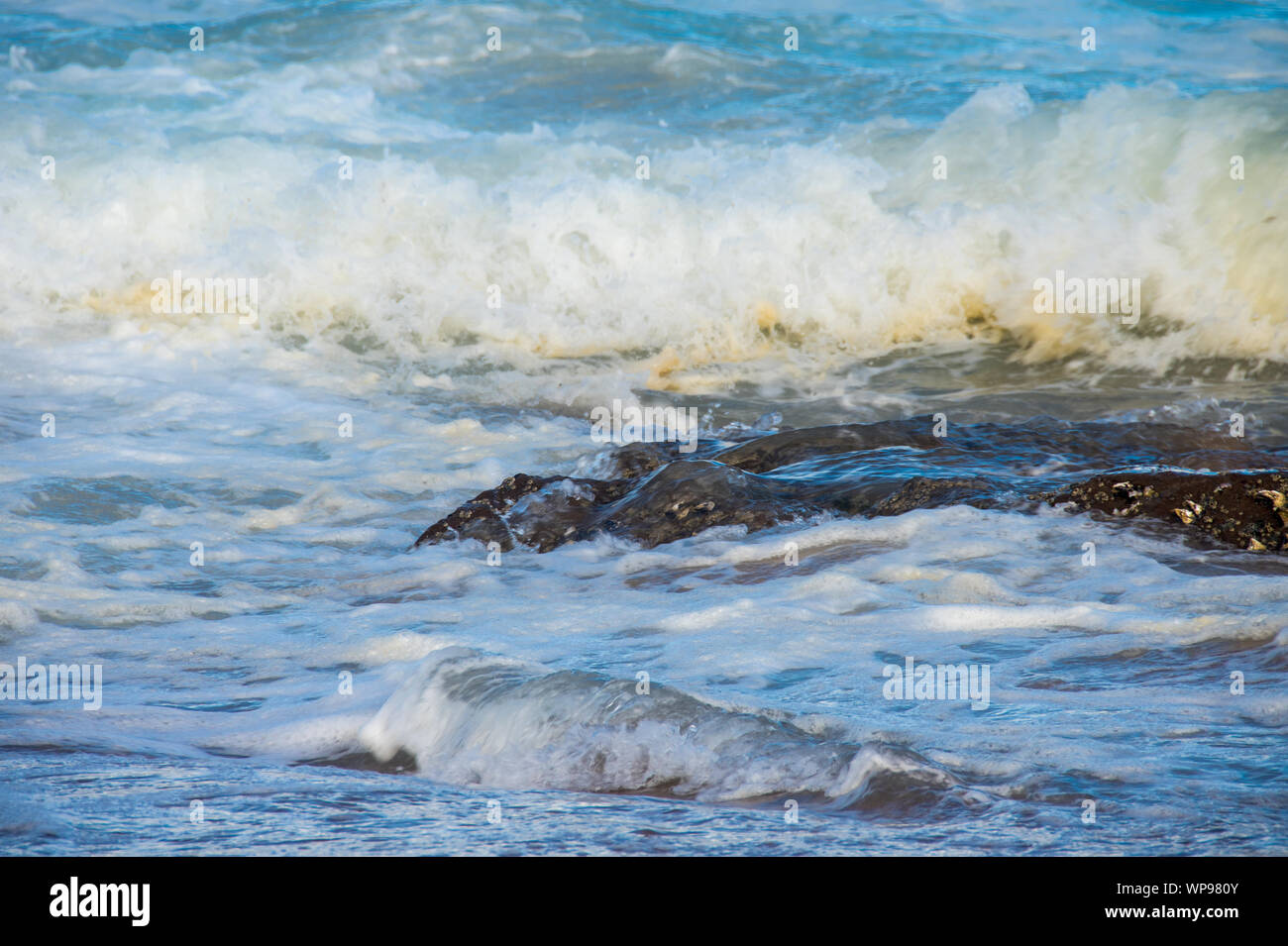 Strong afternoon tide, incoming tide with waves crashing on the rocks ...