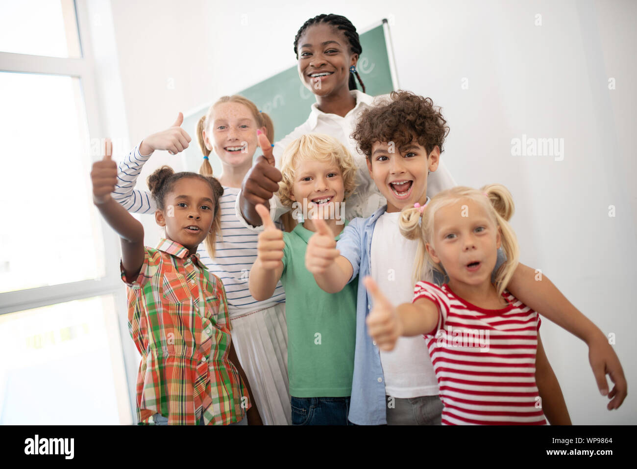 Children showing thumbs up while feeling amazing after lesson Stock ...