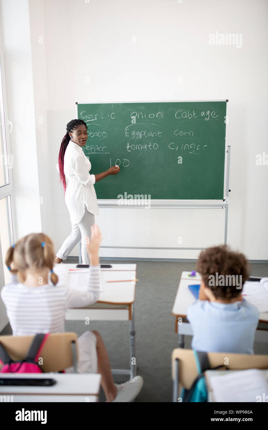 Teacher standing near blackboard and explaining new material Stock ...