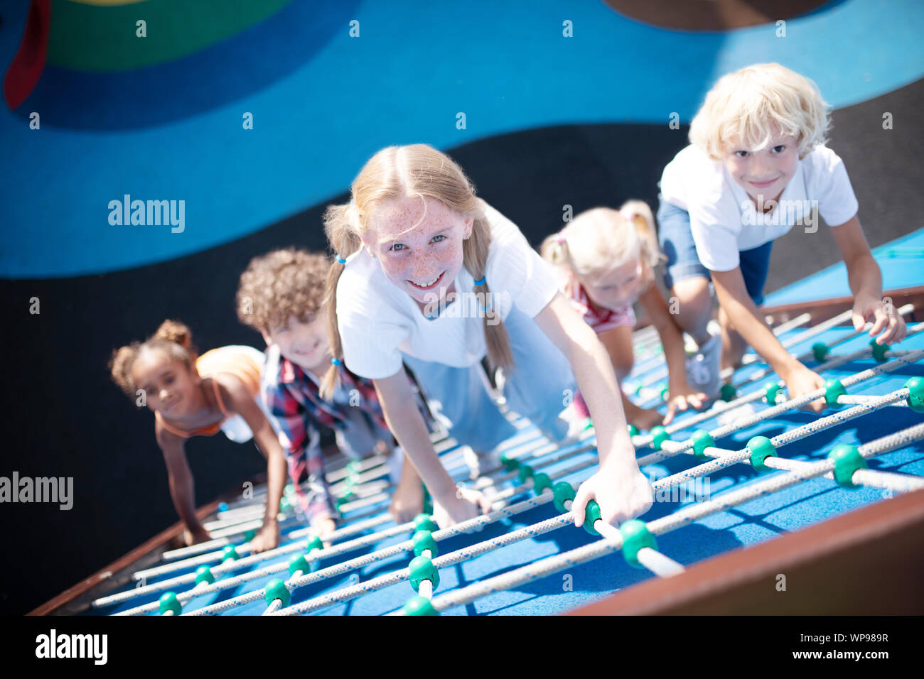 Children climbing the ropes while enjoying outdoors activities Stock ...
