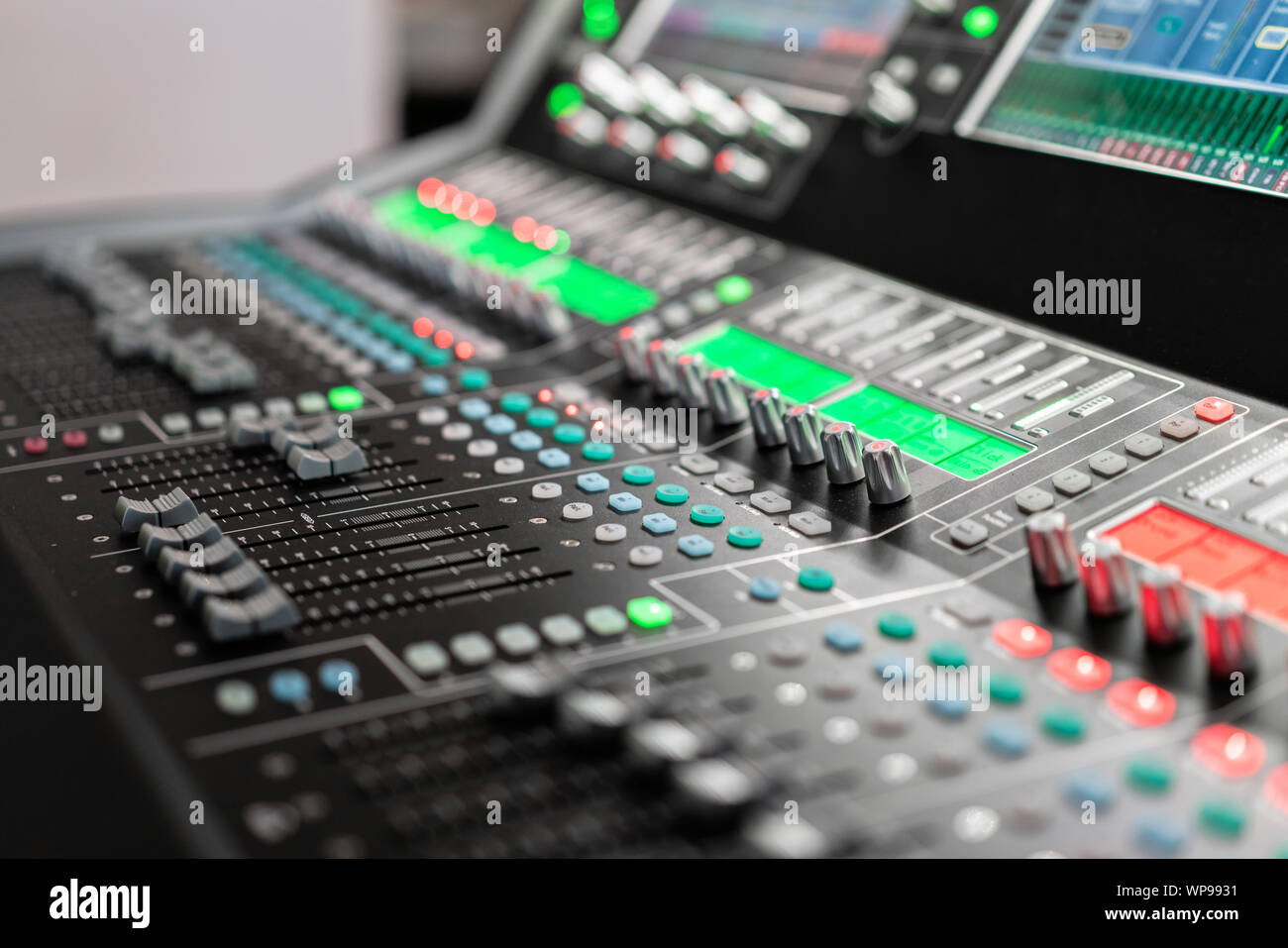 od adjusters and red buttons of a mixing console. It is used for audio ...