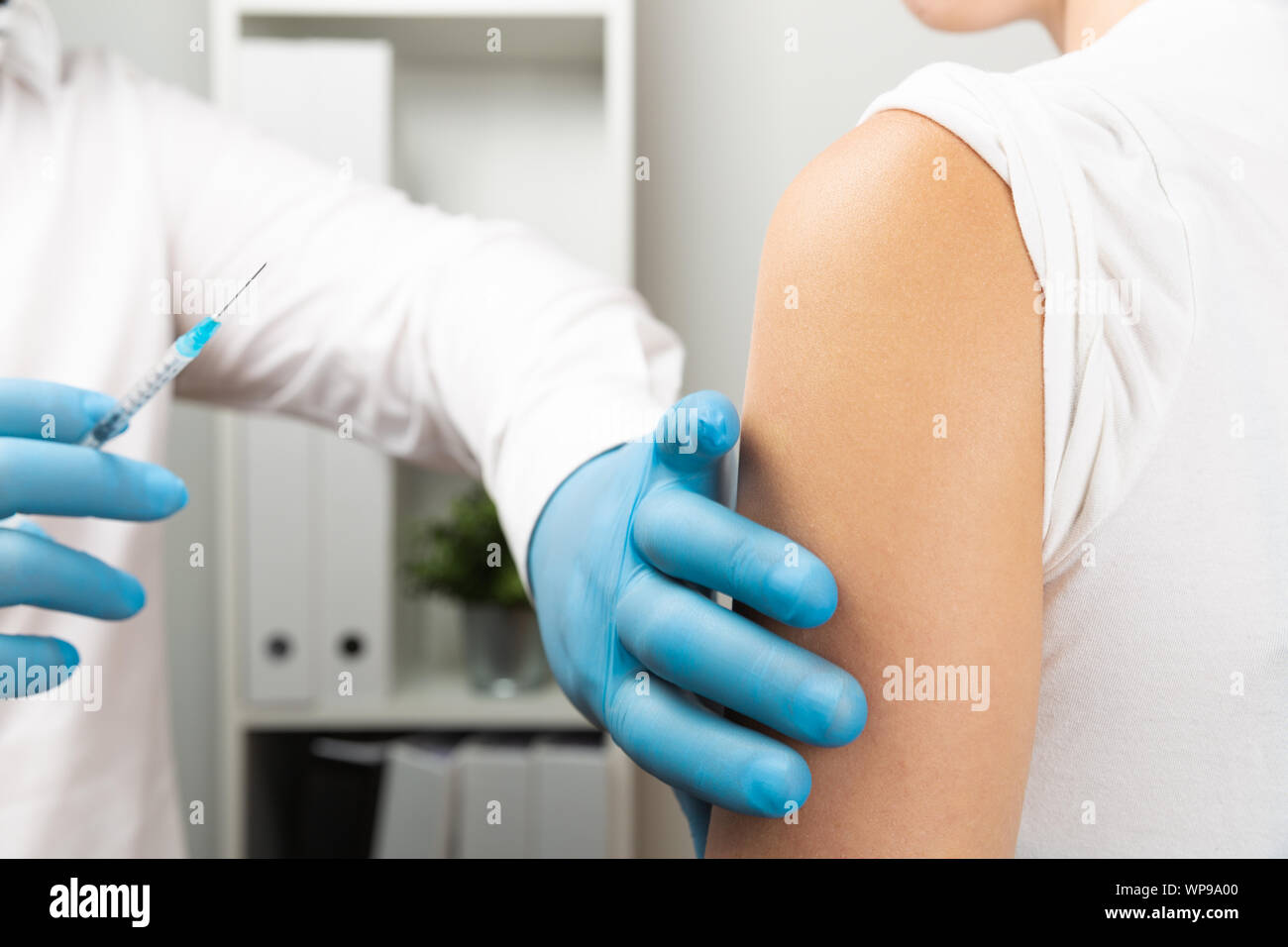 Doctor giving patient vaccine, flu shot. Doctor making a vaccination in ...
