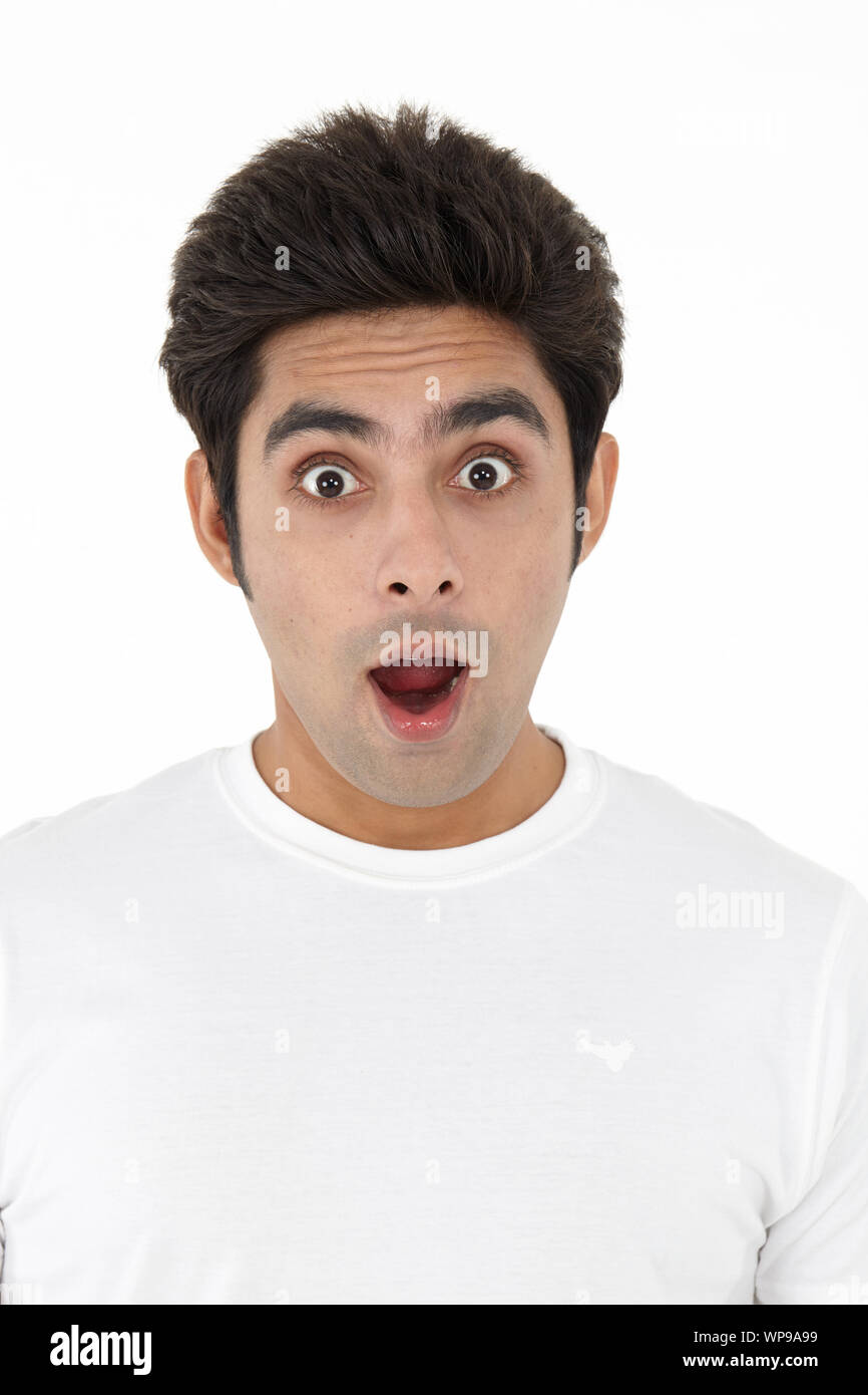 Portrait of a young man looking shocked Stock Photo - Alamy