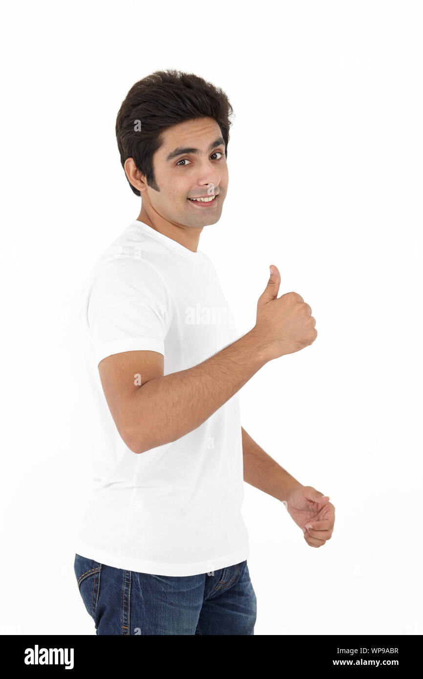 Side profile of a young man showing thumbs up sign Stock Photo - Alamy