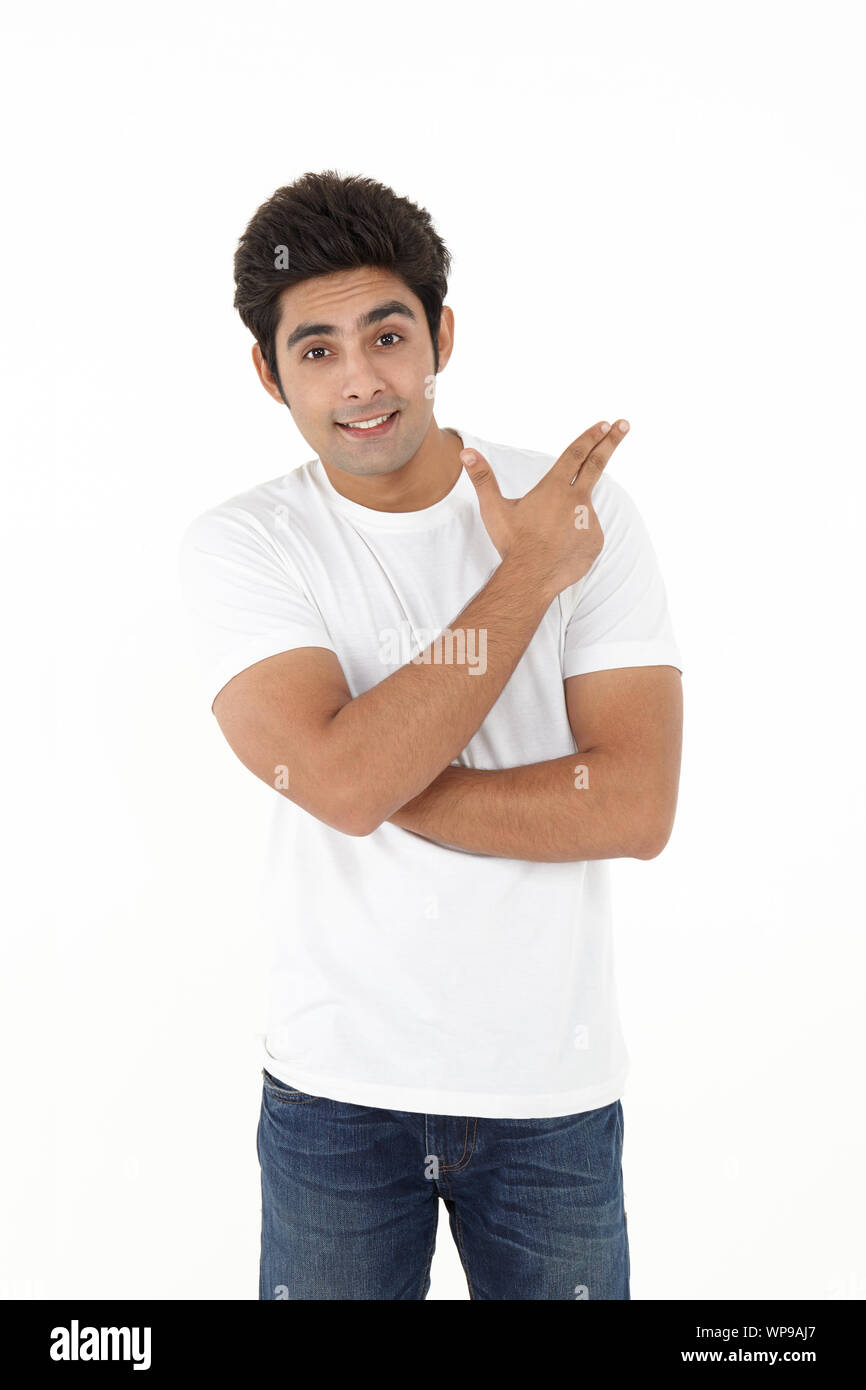 Young man making a gun sign and smiling Stock Photo - Alamy