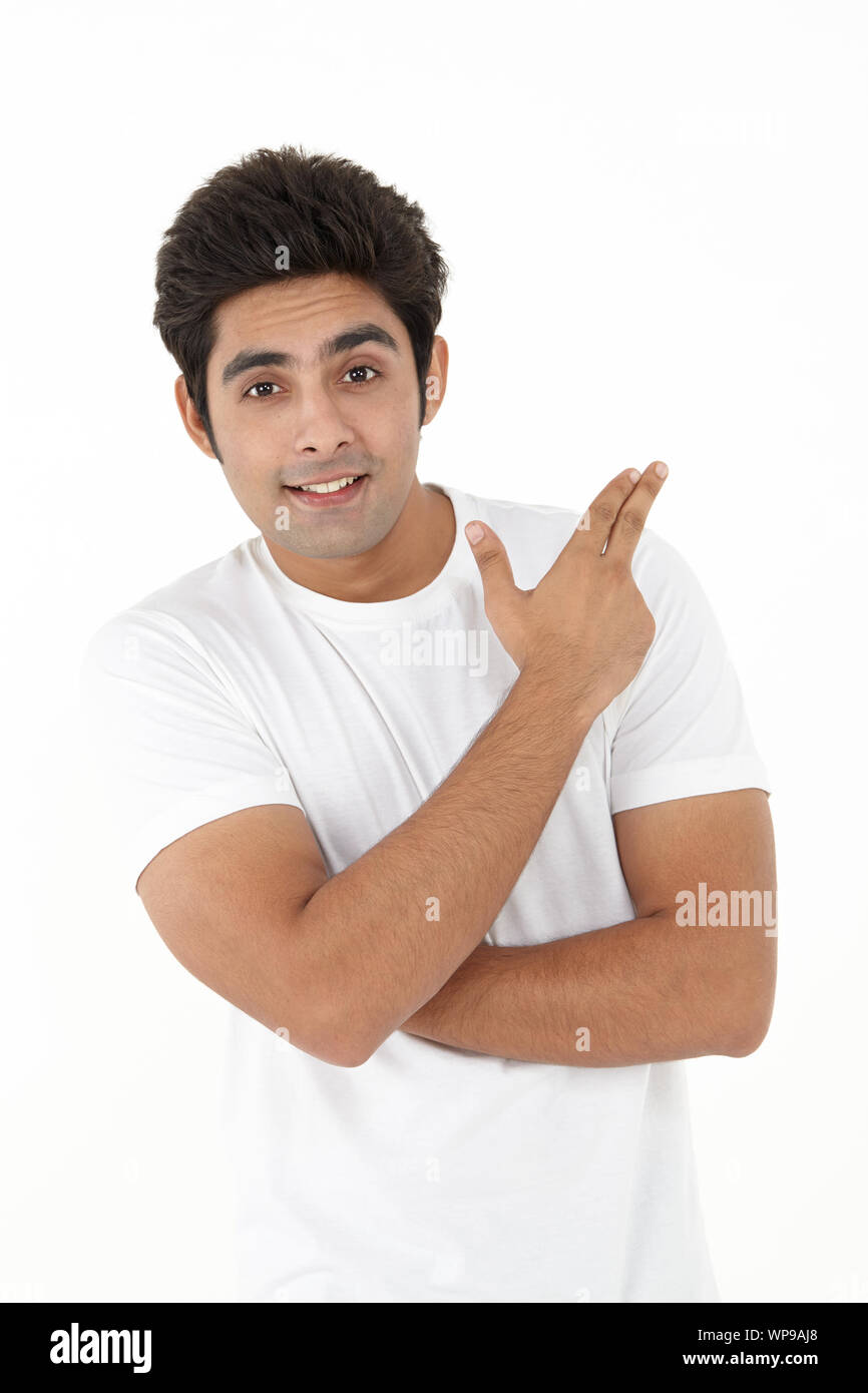 Young man making a gun sign and smiling Stock Photo - Alamy
