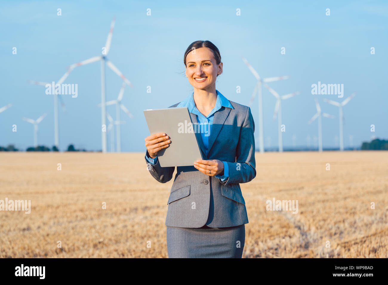 Investor in wind turbines with computer evaluating her investment on ...