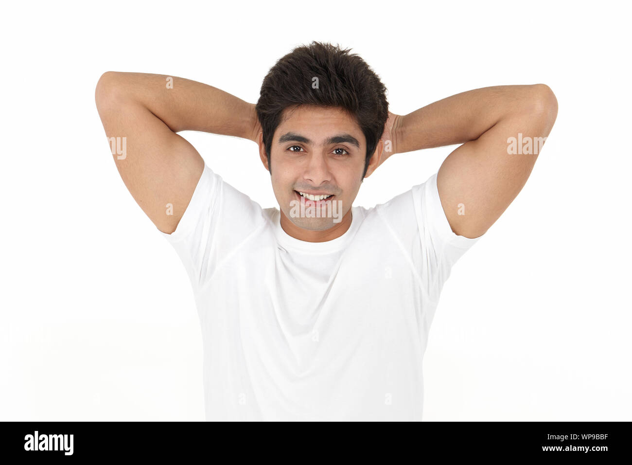 Young man smiling with his hands behind back Stock Photo - Alamy