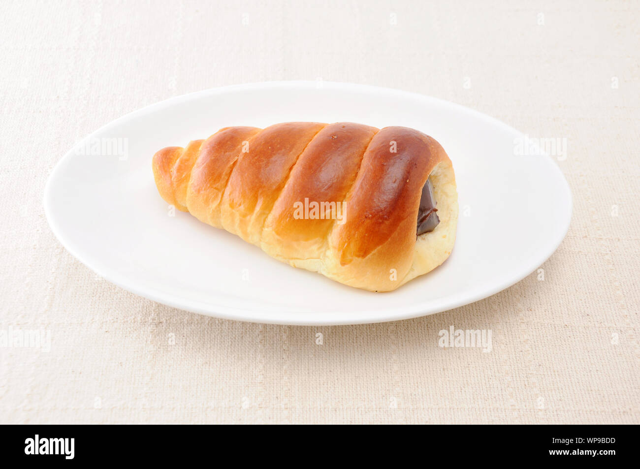 chocolate cornet butter bread roll on a plate isolated on table cloth ...
