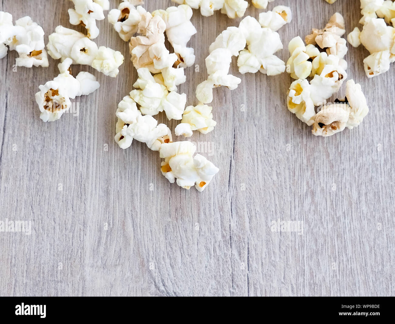 popcorn on wooden background, copy space. Scattered salted popcorn ...