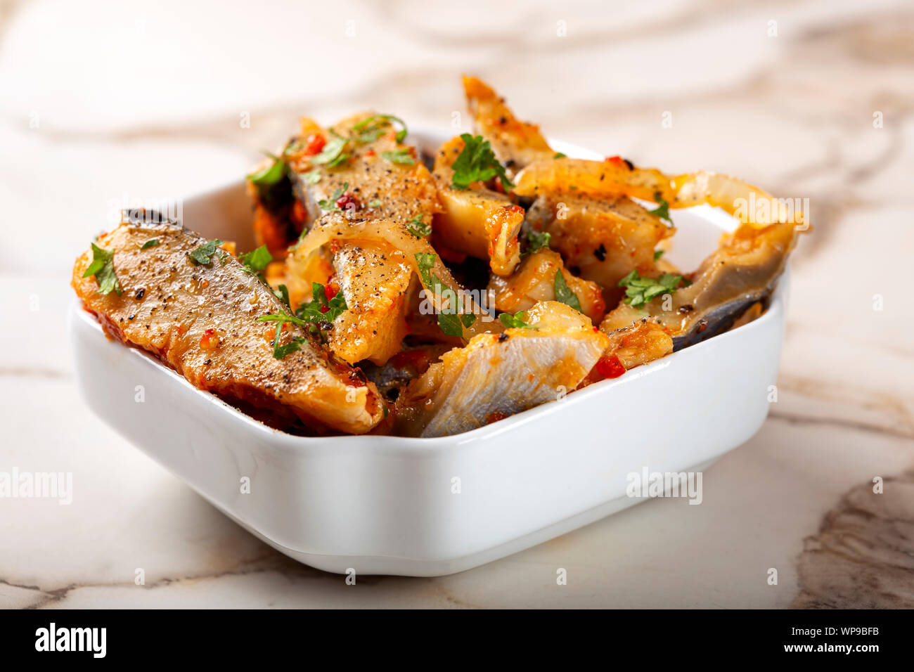 Marinated hering fish with spices and herbs in a white bowl Stock Photo ...