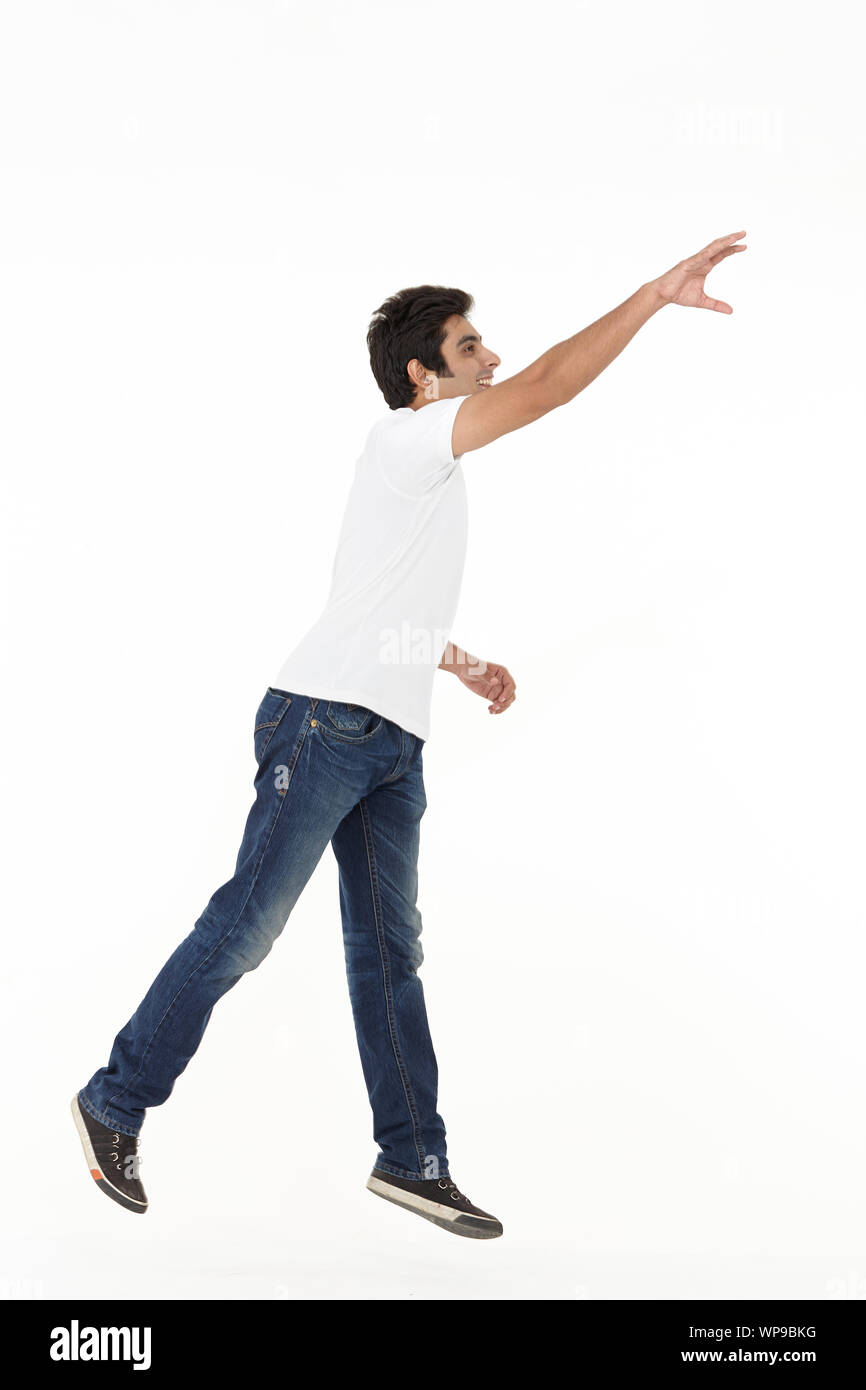 Young man reaching in air Stock Photo - Alamy