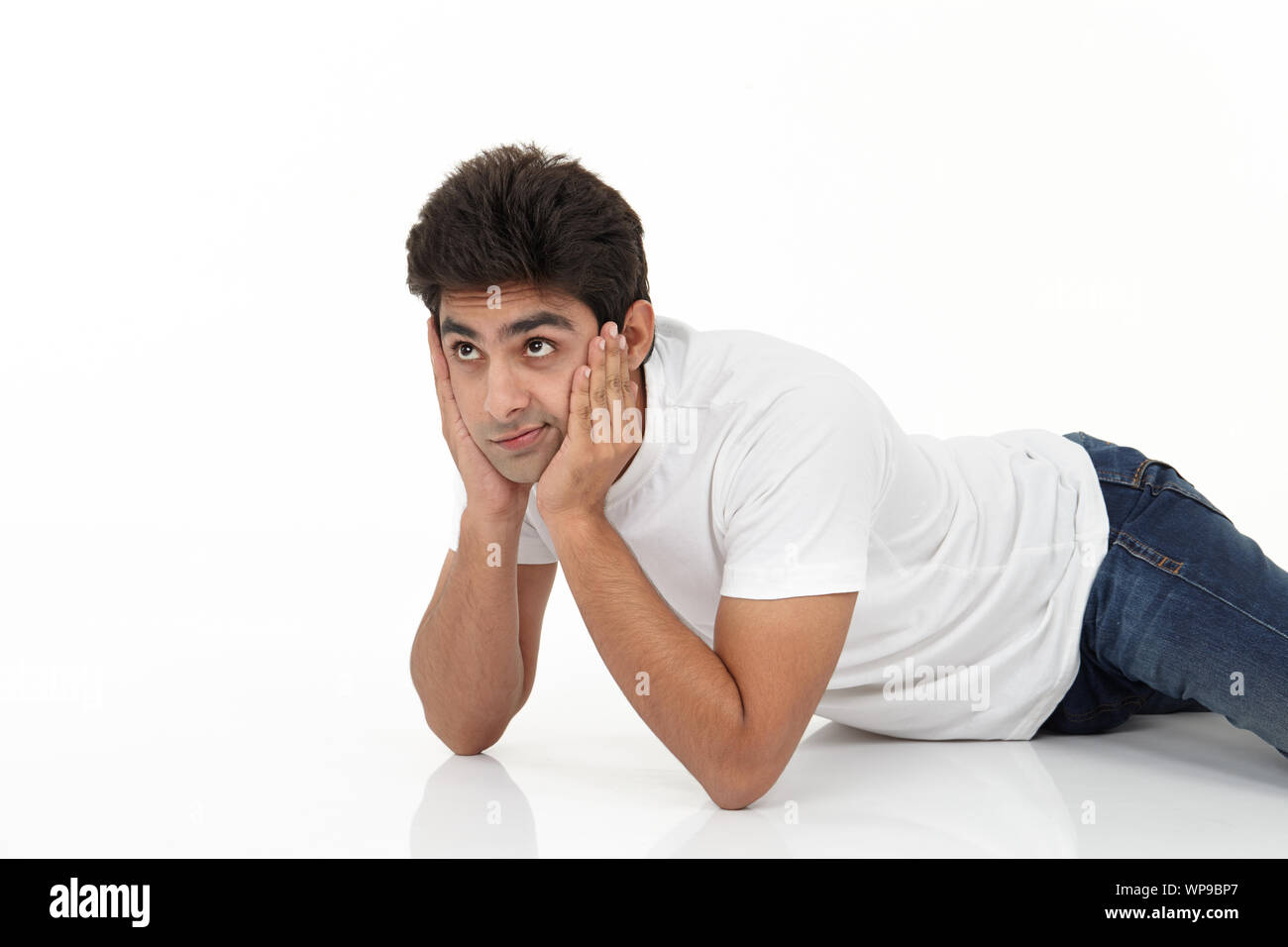 Young man thinking with lying on floor Stock Photo - Alamy
