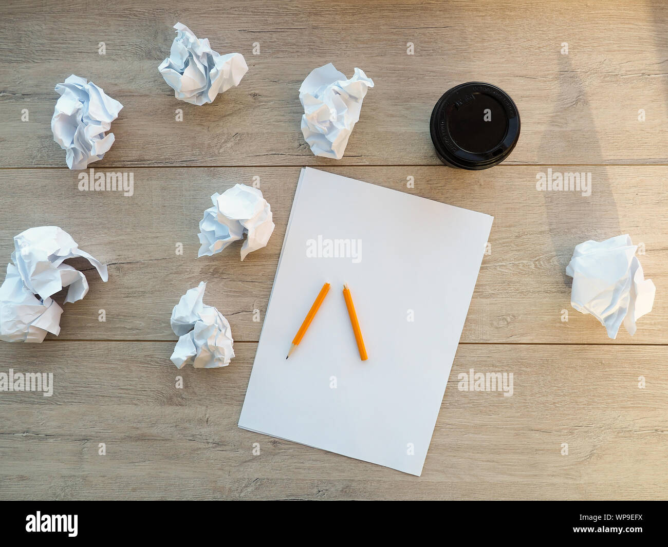 Writing concept - crumpled up paper wads with a sheet of white paper ...