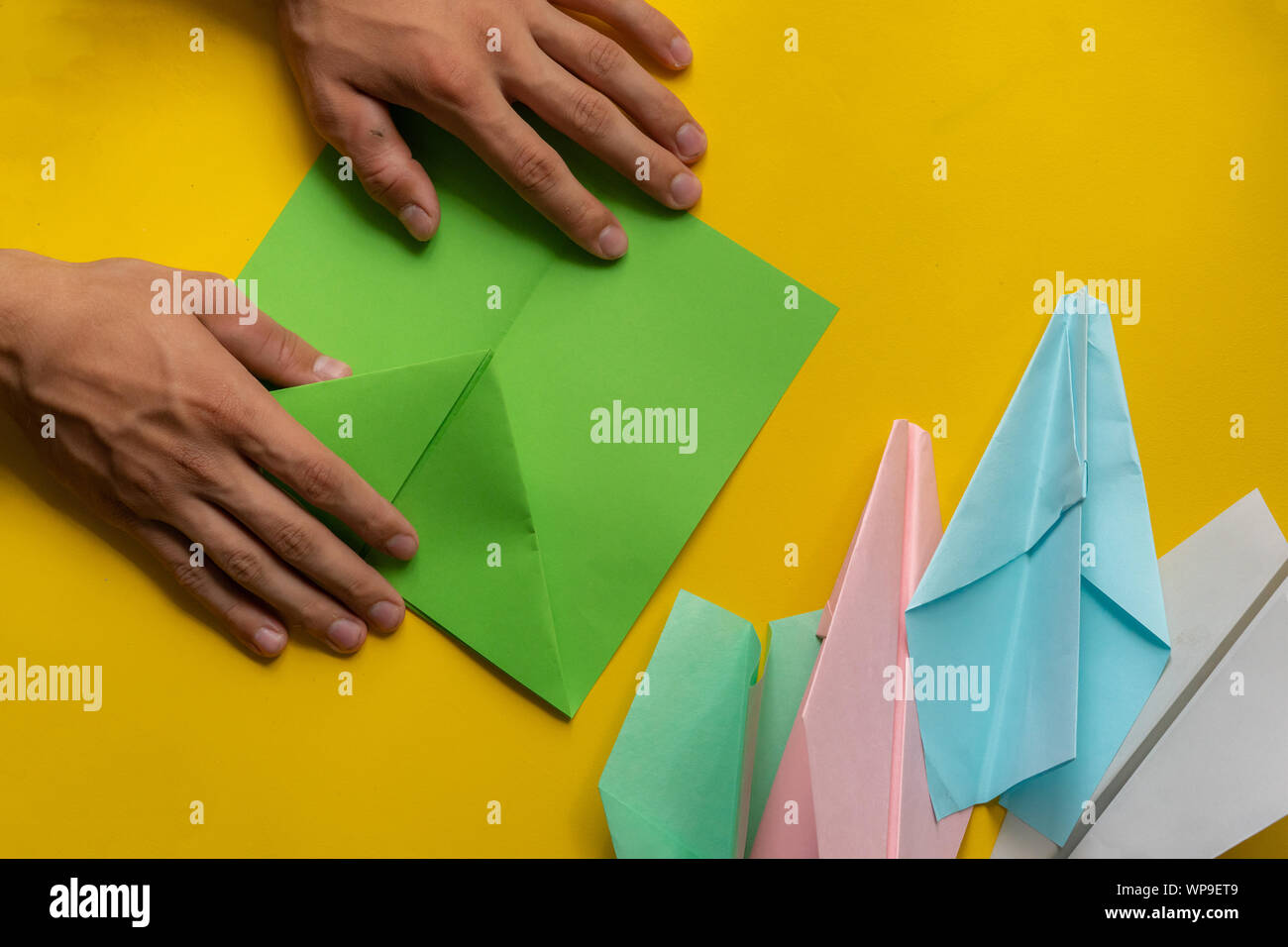 person hands making a origami color paper planes Stock Photo - Alamy