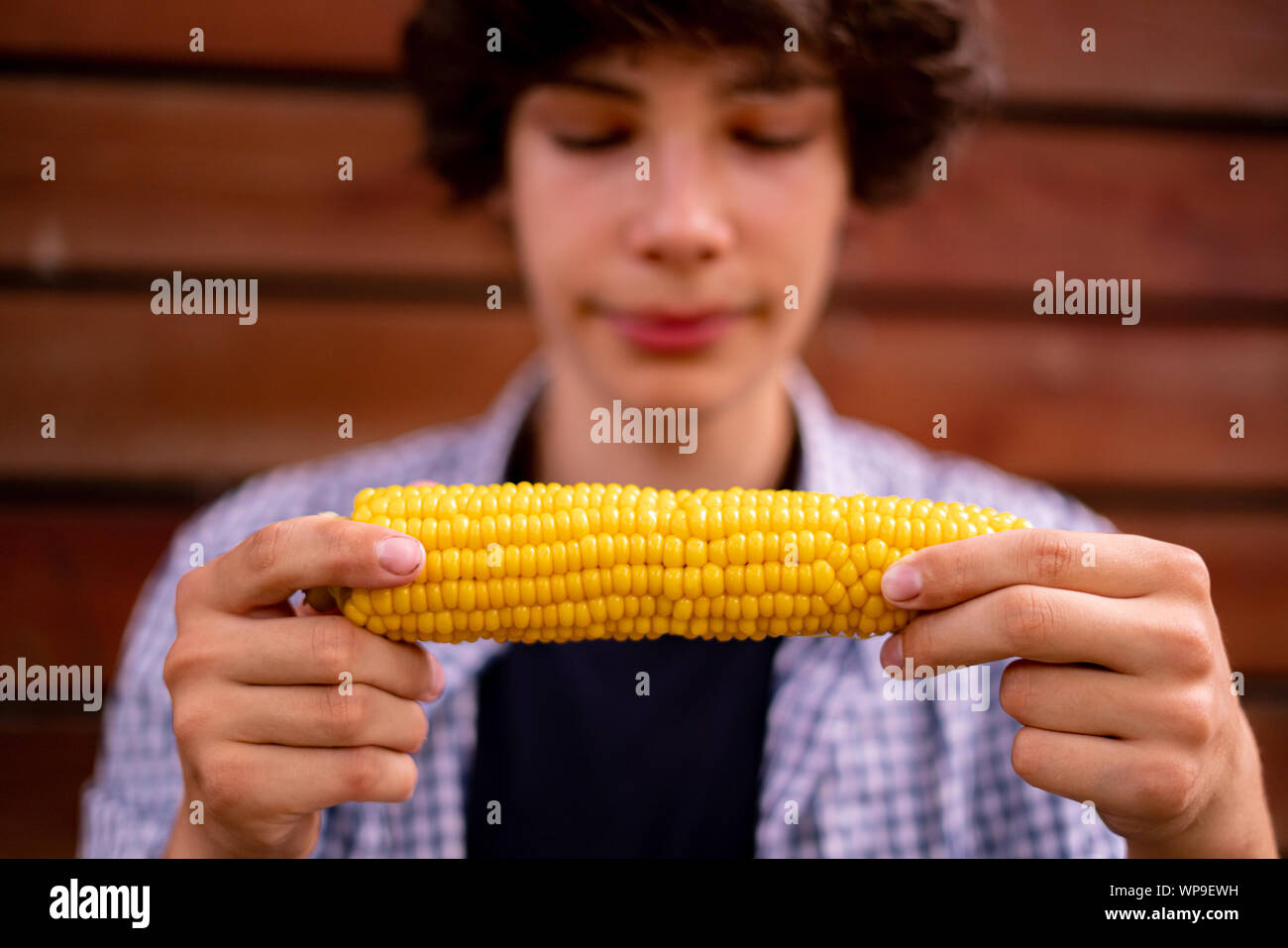 close up person eating and biting cooked hot prepared corn, street food ...