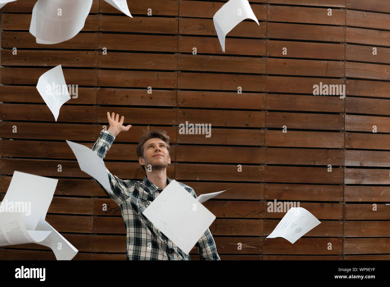 young stressed man throw crumpled paper files in the air, freedom ...