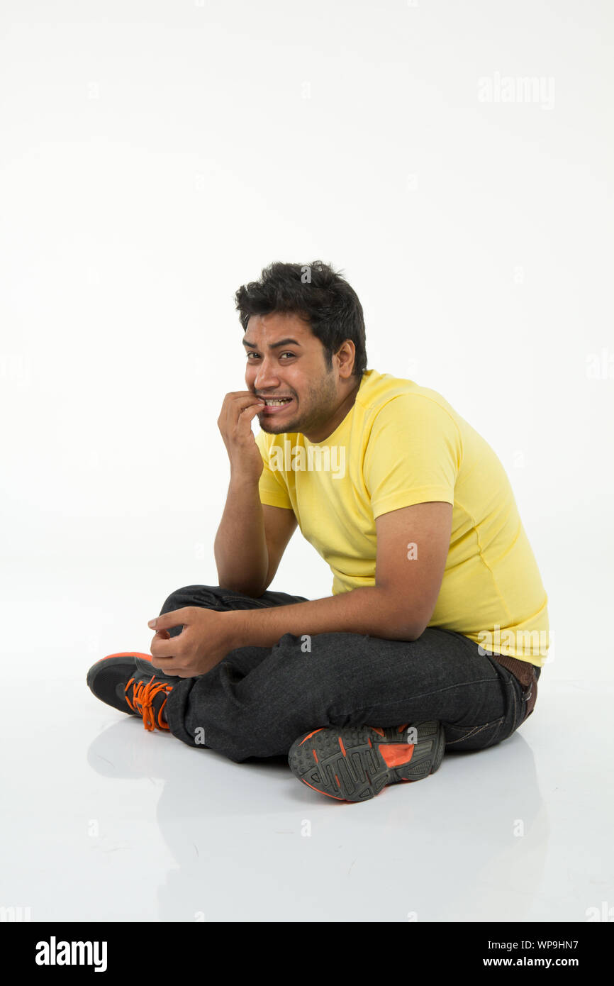 Worried young man biting hi-res stock photography and images - Alamy