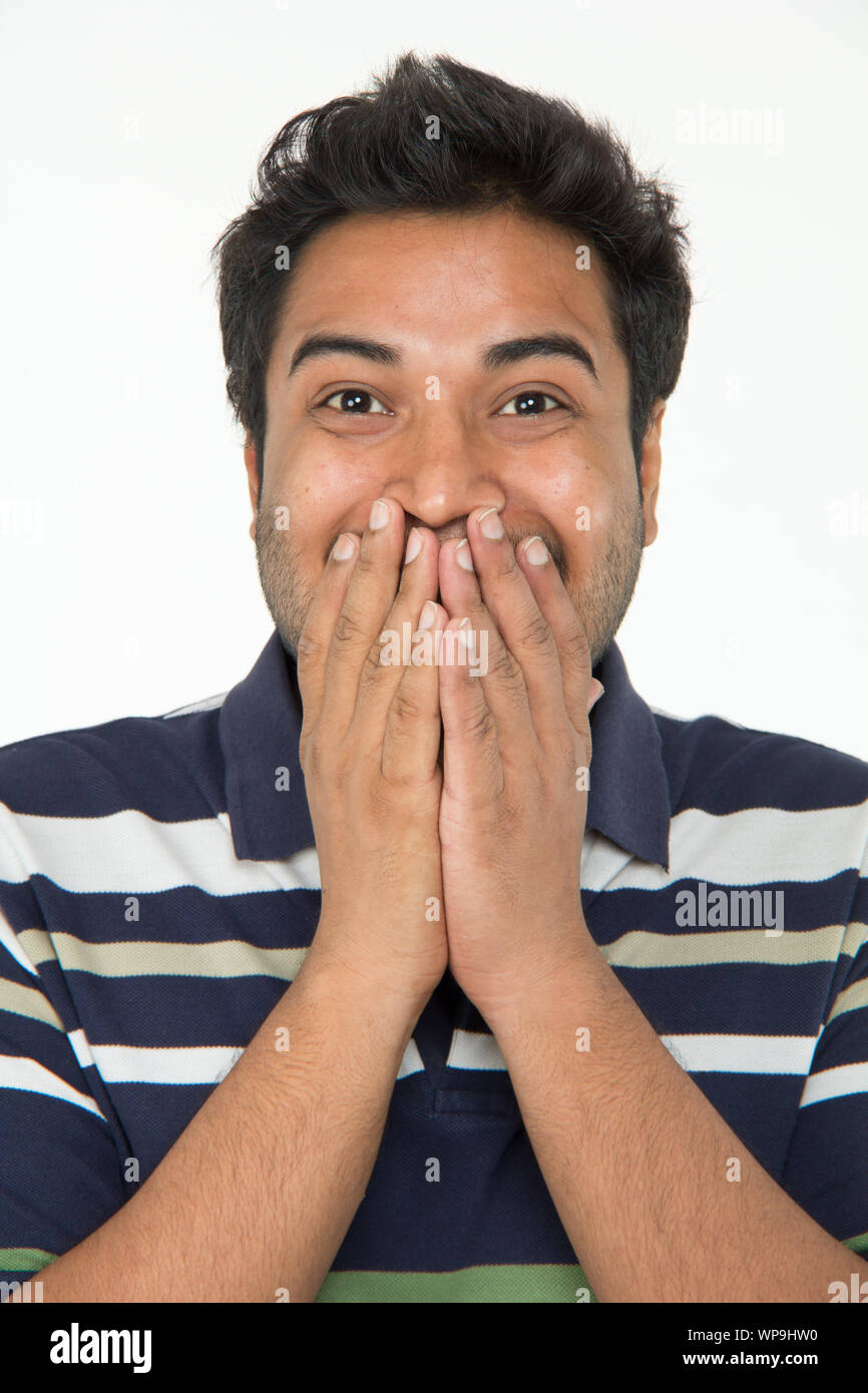 Surprised young man covering his mouth Stock Photo - Alamy