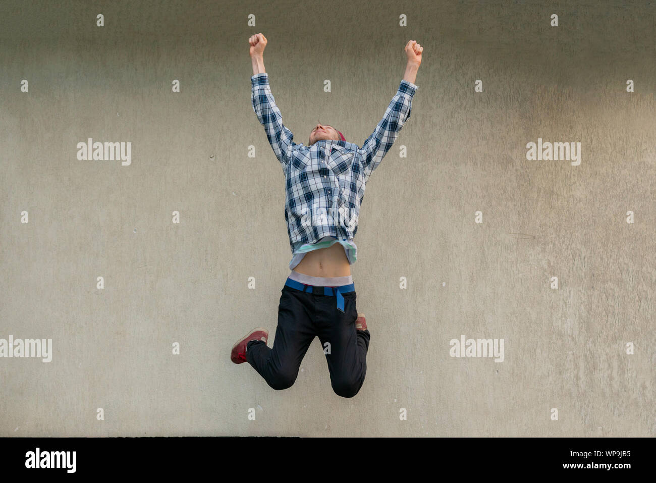 young man jumping high, winning or success gesture signs Stock Photo ...