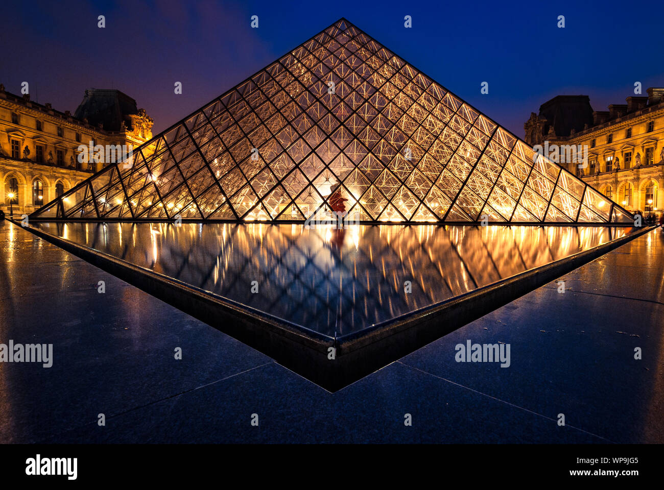 A view to Louvre, Paris with water reflection in a fountain and glass ...