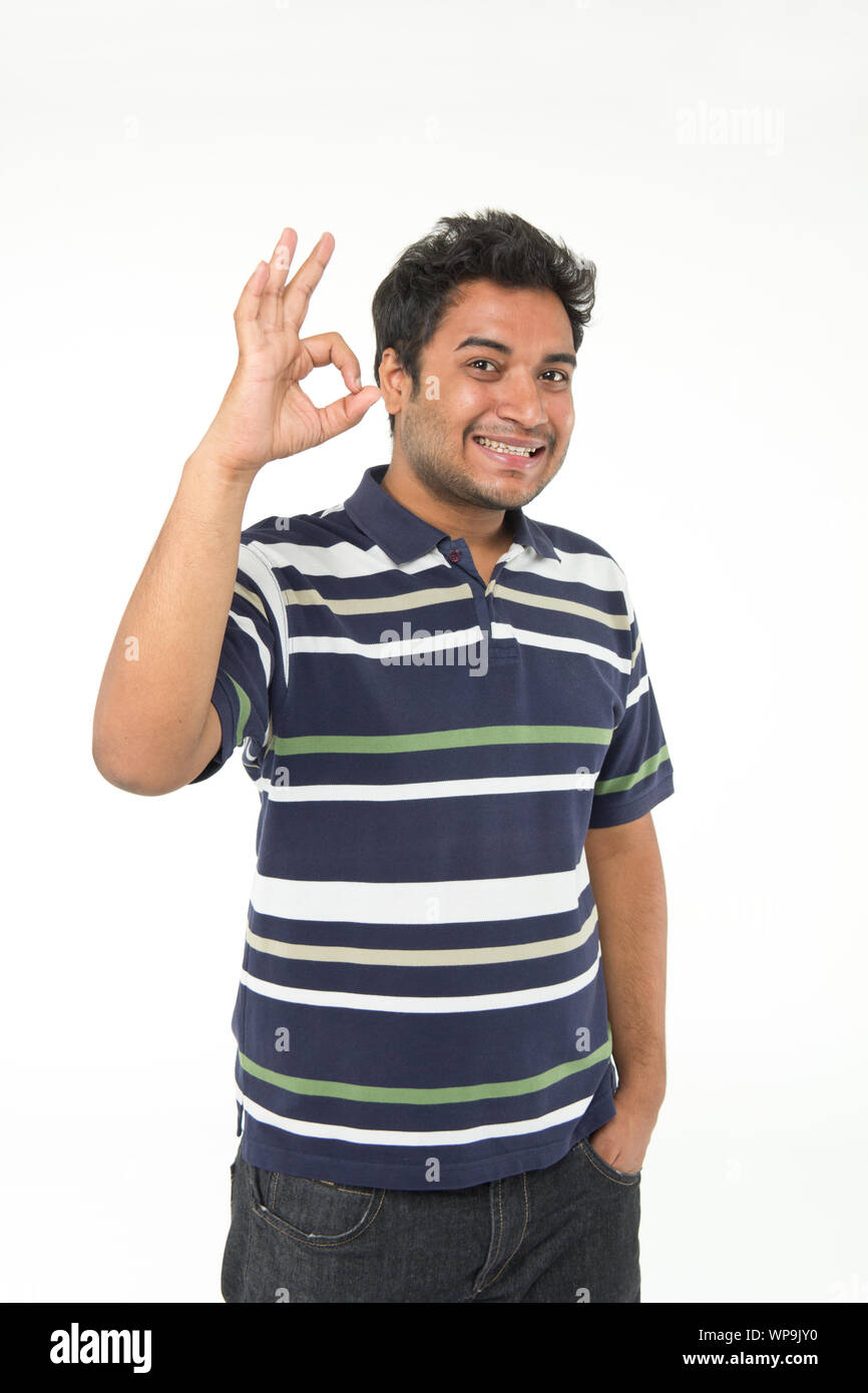 Young man showing OK sign and smiling Stock Photo - Alamy