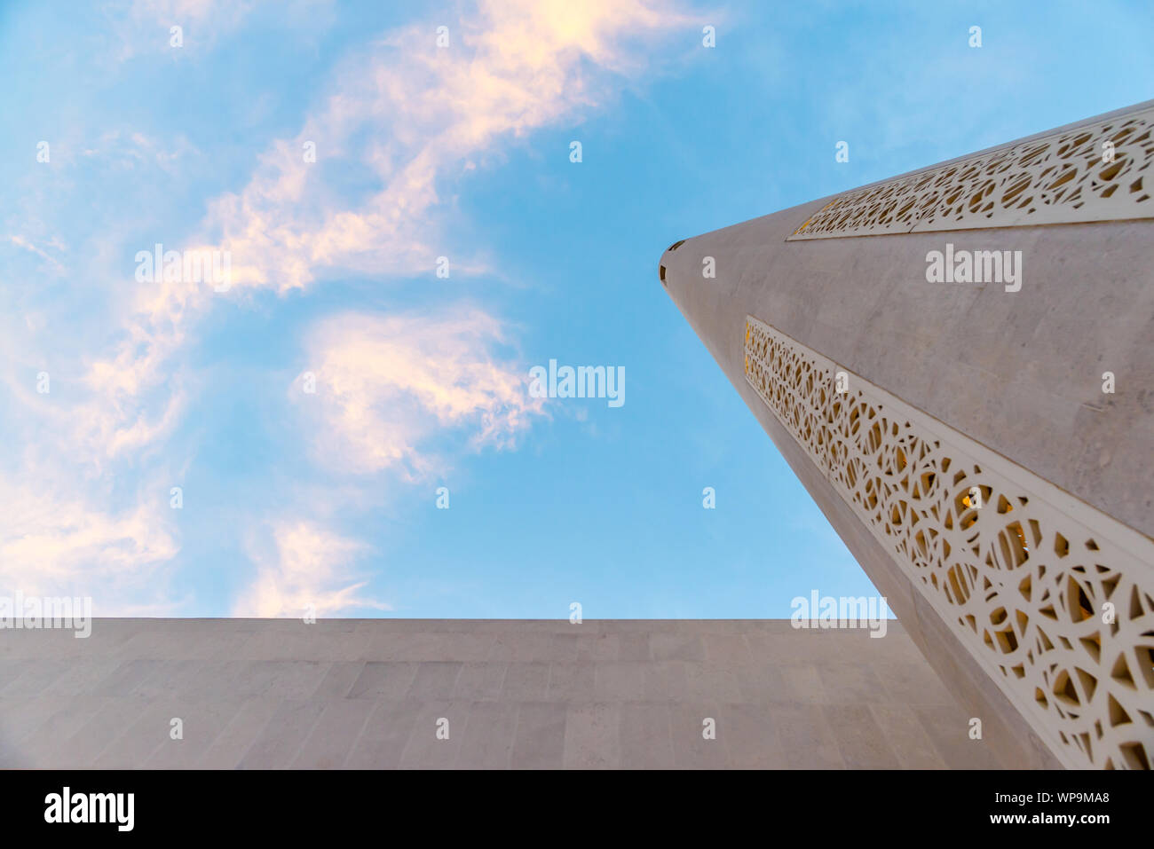 Minaret of the Msheireb mosque seen from below with blue sky and clouds ...