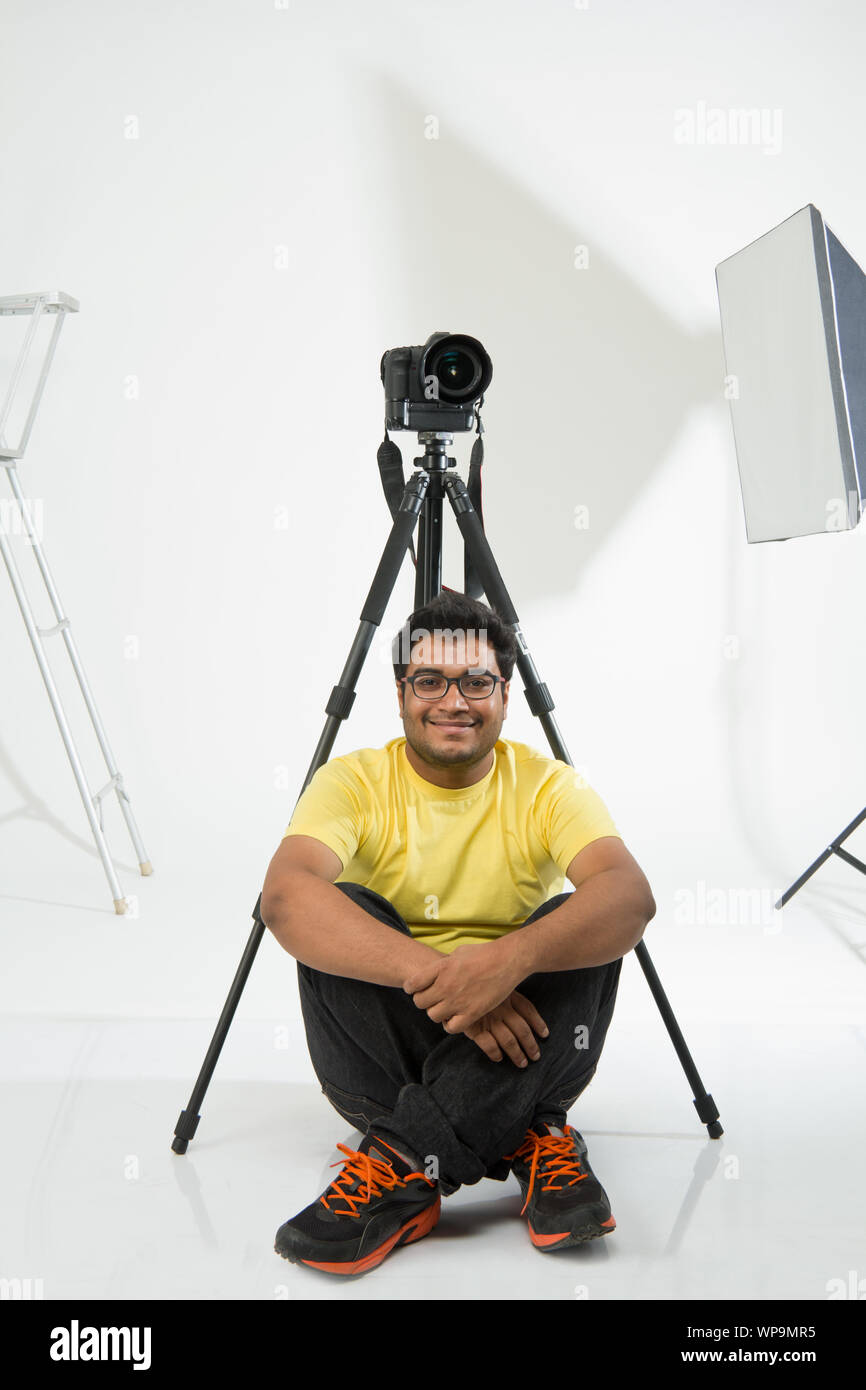 Photographer sitting on floor in studio Stock Photo - Alamy