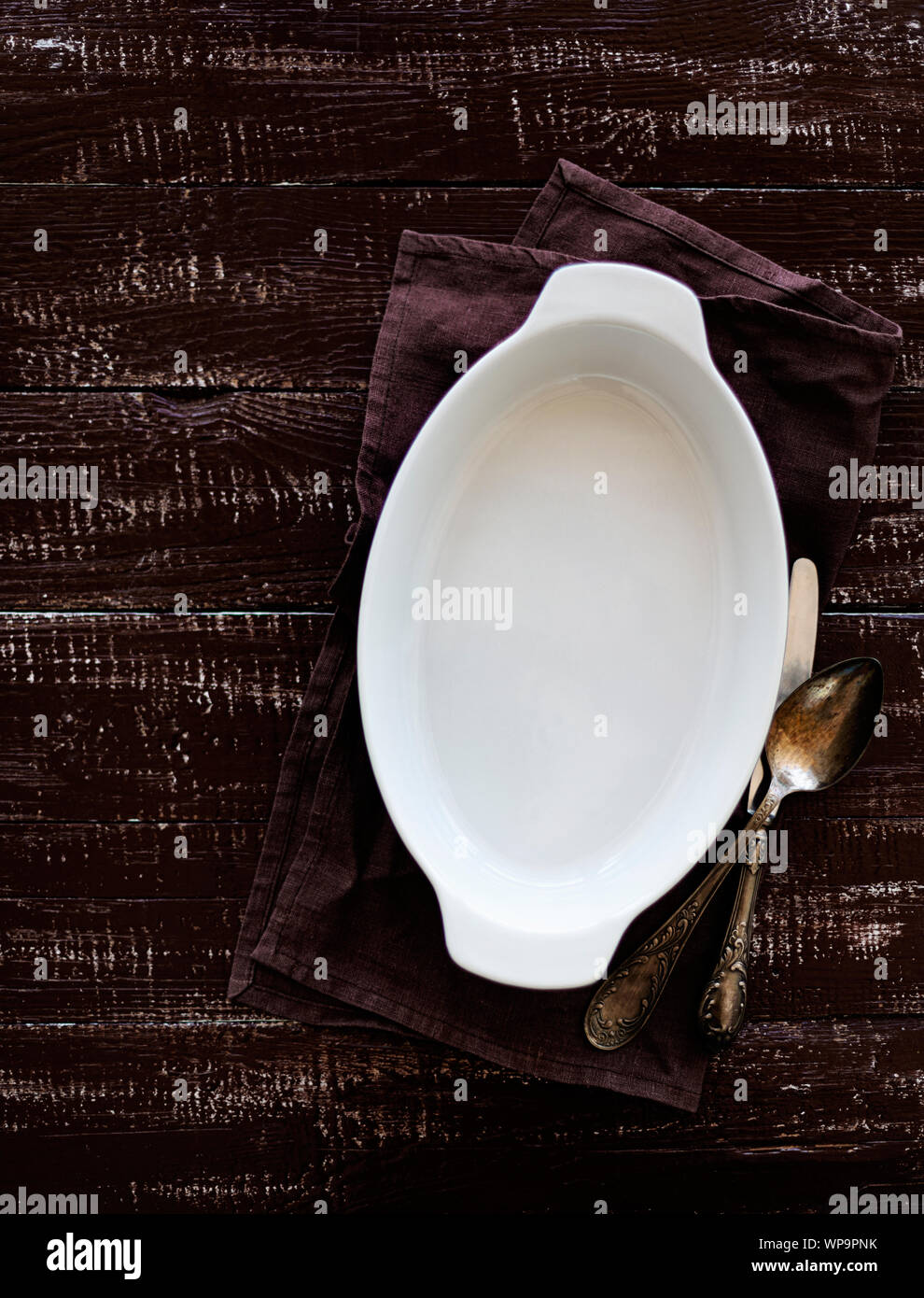 Ceramic white baking dish on a wooden old background. Selective focus ...
