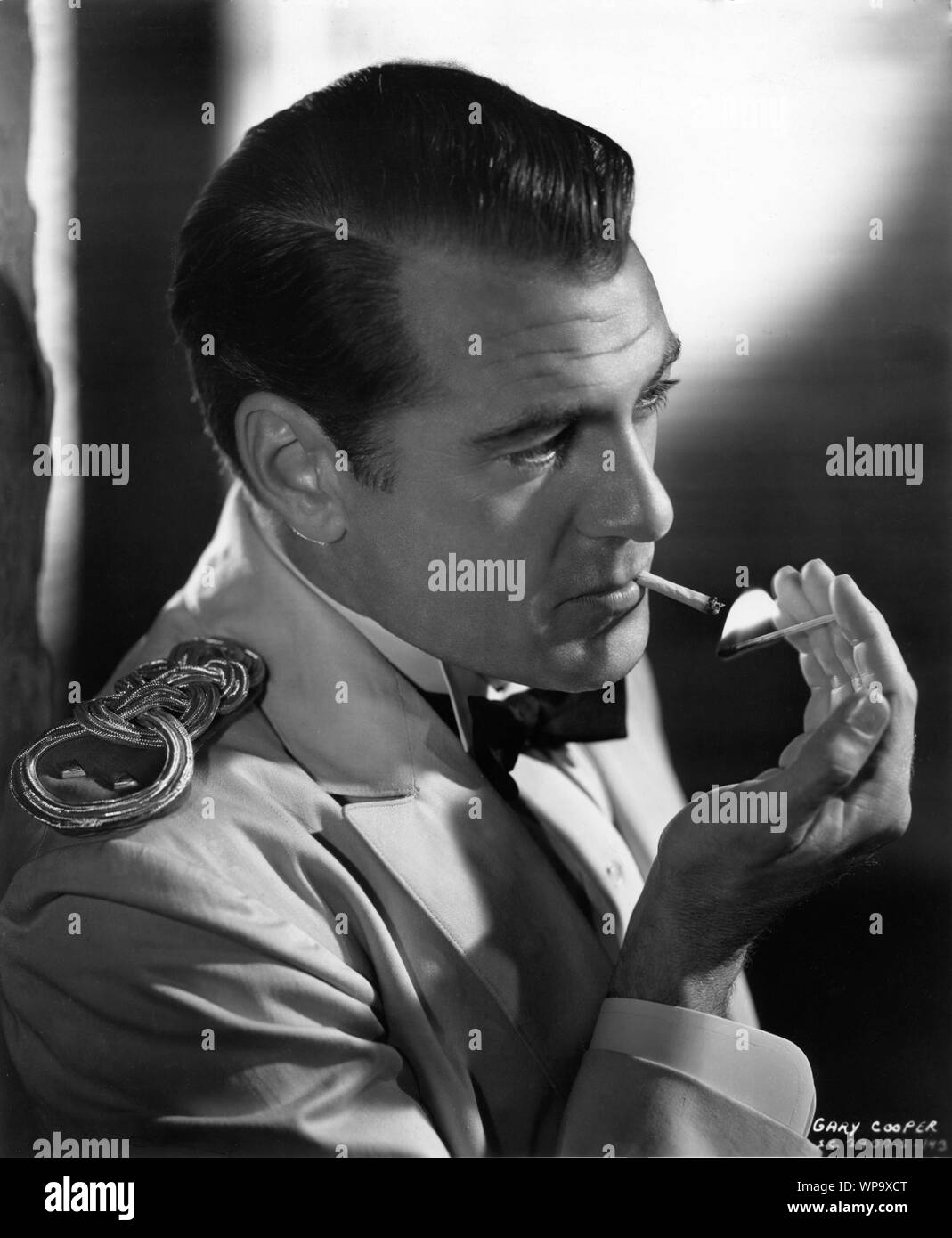 GARY COOPER portrait as Dr Bill Canavan lighting up a roll up cigarette ...