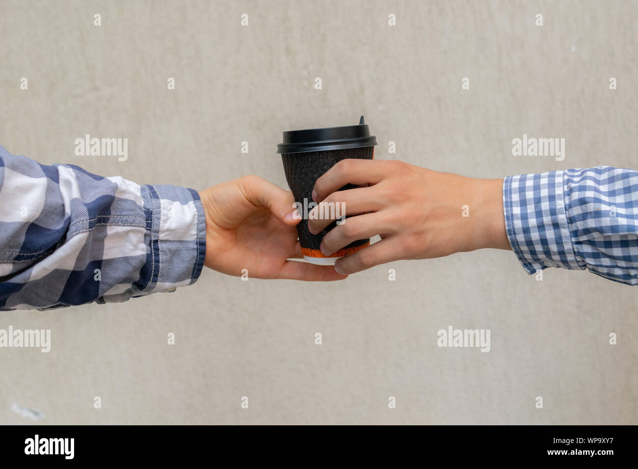 giving a cup of fresh hot espresso, two hands deliver and recieve ...