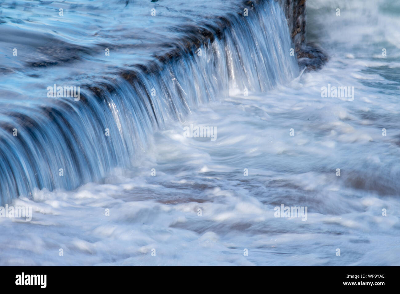 Strong afternoon, incoming tide with waves crashing on a tidal pool ...