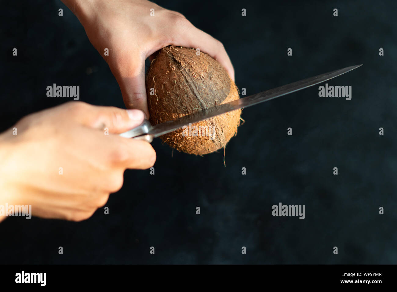 person with big knife try to open and break a coconuts Stock Photo - Alamy