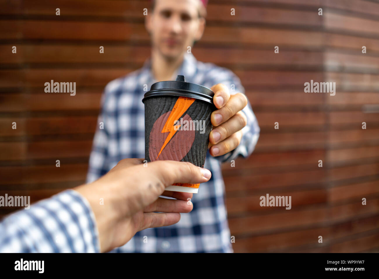 giving a cup of fresh hot espresso, two hands deliver and recieve ...