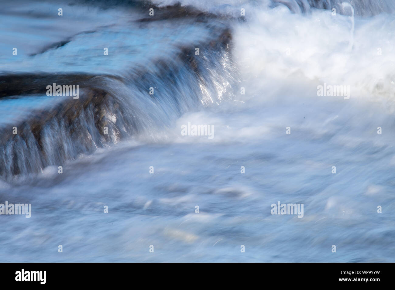 Strong afternoon, incoming tide with waves crashing on a tidal pool ...