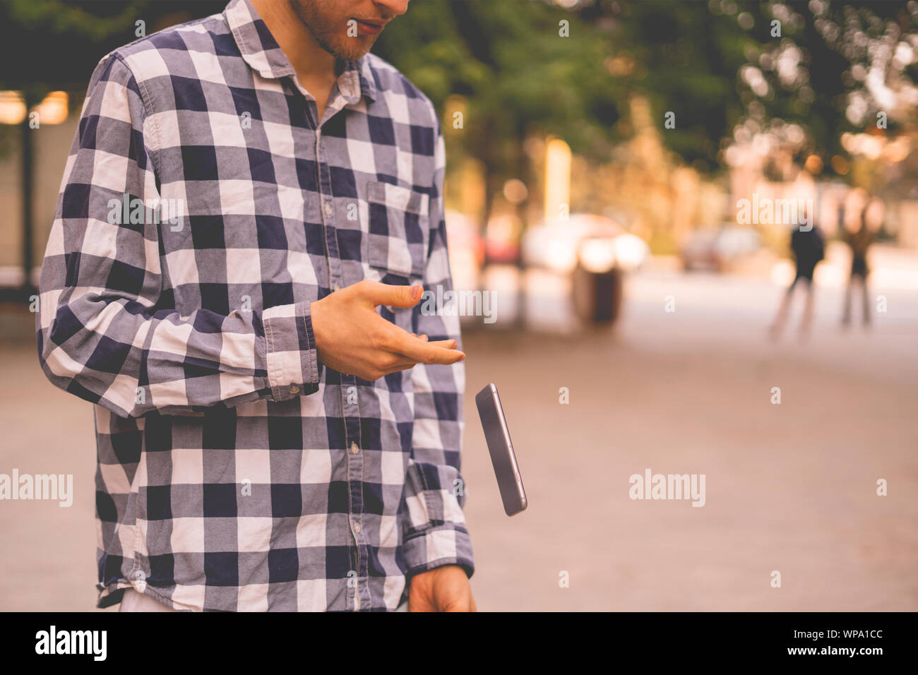 person holding a smartphone in the street, a phone falling and flying ...