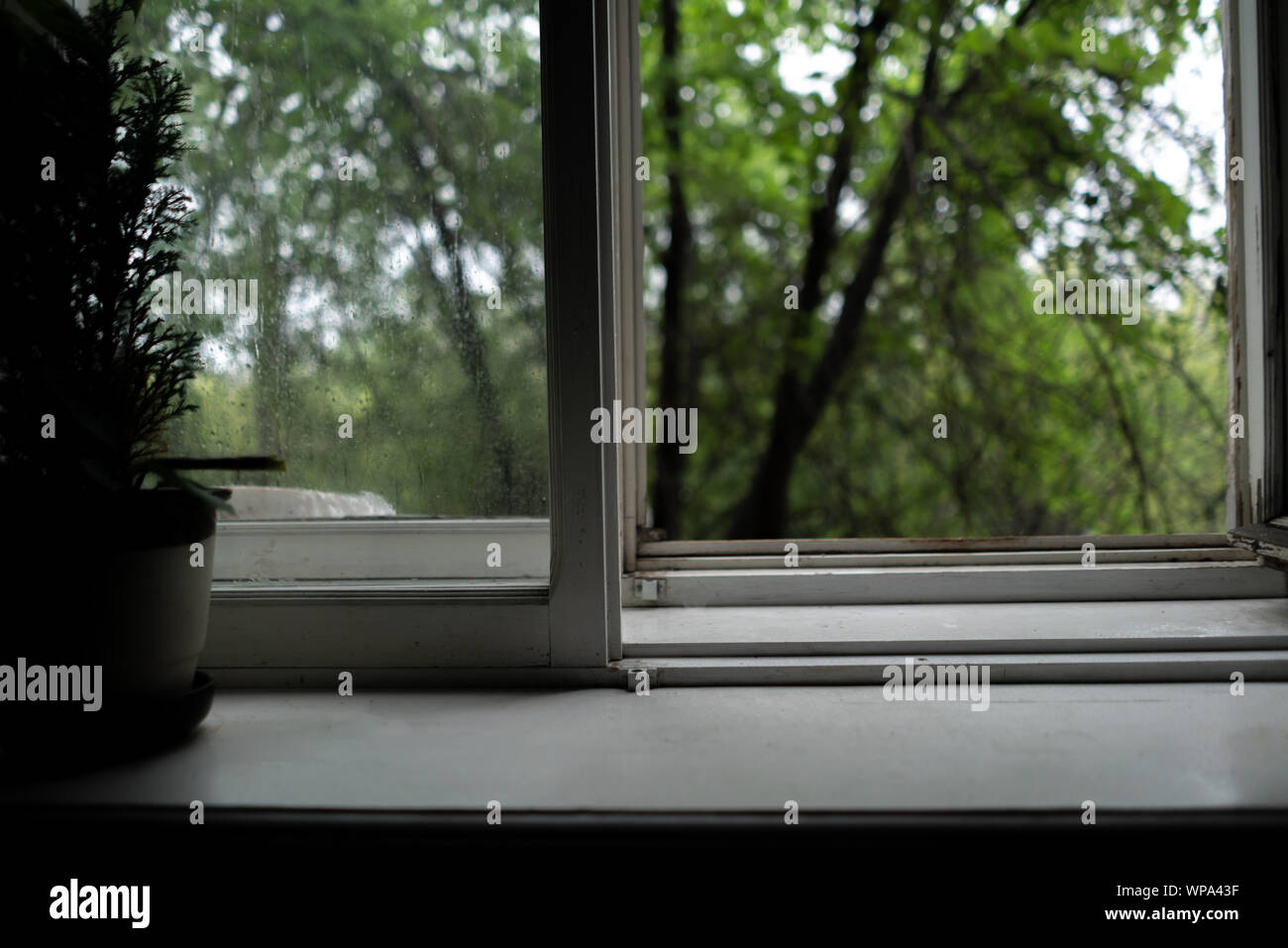 nostalgic concept, opened window in cozy walm home while it rains ...