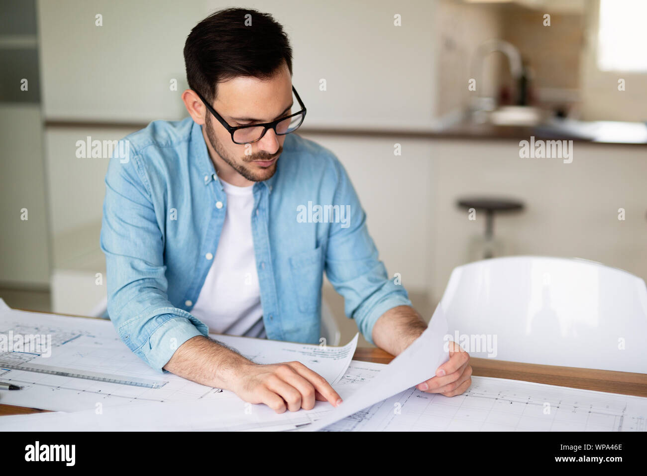 Architect working on drawing table in office Stock Photo - Alamy