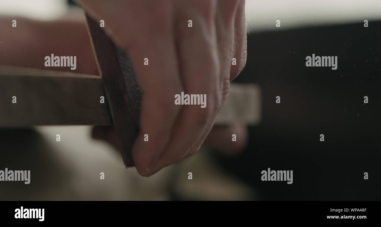 woodworker hand sanding walnut board with sand block, wide photo Stock ...